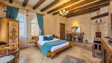 Quarto tradicional com cama de madeira, uma escrivaninha, uma cadeira e um espelho.