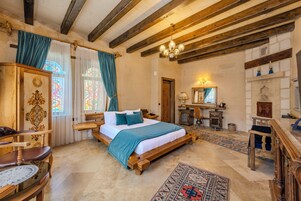 Quarto tradicional com cama de madeira, uma escrivaninha, uma cadeira e um espelho.