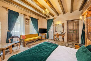 Quarto tradicional com uma cama, móveis de madeira, uma televisão e uma porta de madeira.