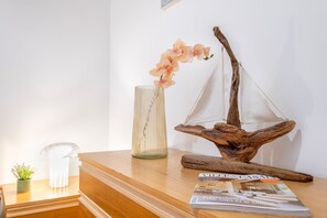 Uma mesa de madeira com um vaso de flores, uma revista e um objeto decorativo.