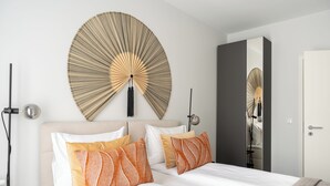 Quarto moderno com uma cama grande, dois ventiladores decorativos na parede e um guarda-roupa.