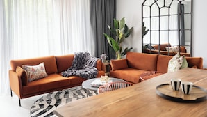Uma sala de estar moderna com um sofá, uma mesa de centro e uma mesa de jantar.