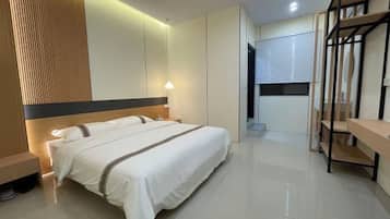 Quarto de hotel moderno com uma cama grande, uma escrivaninha e um guarda-roupa.