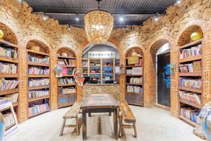Uma livraria com paredes de tijolo, estantes de madeira e uma mesa central.
