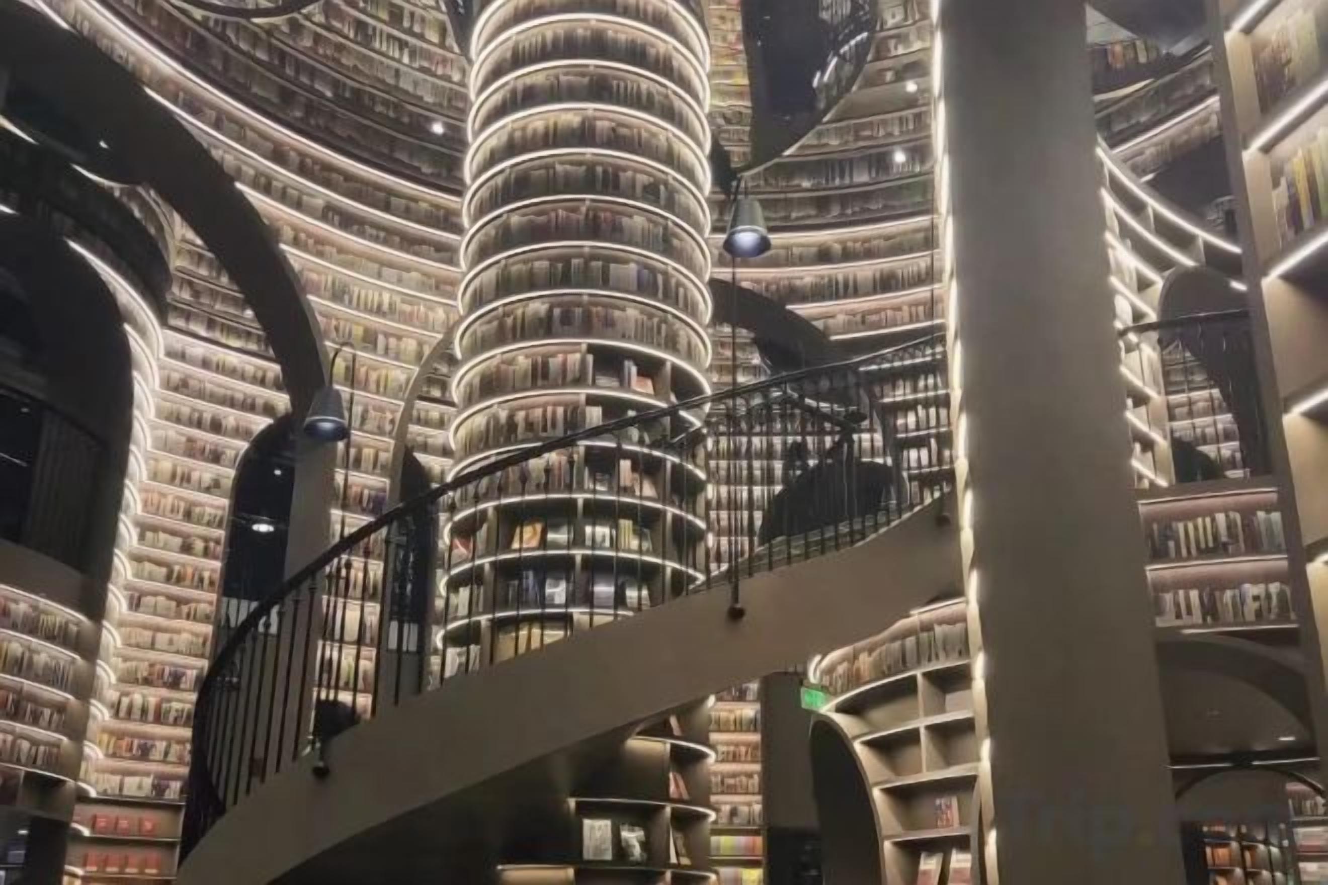 Uma biblioteca com vários níveis, estantes organizadas em espiral, uma escadaria central e design arquitetônico moderno.