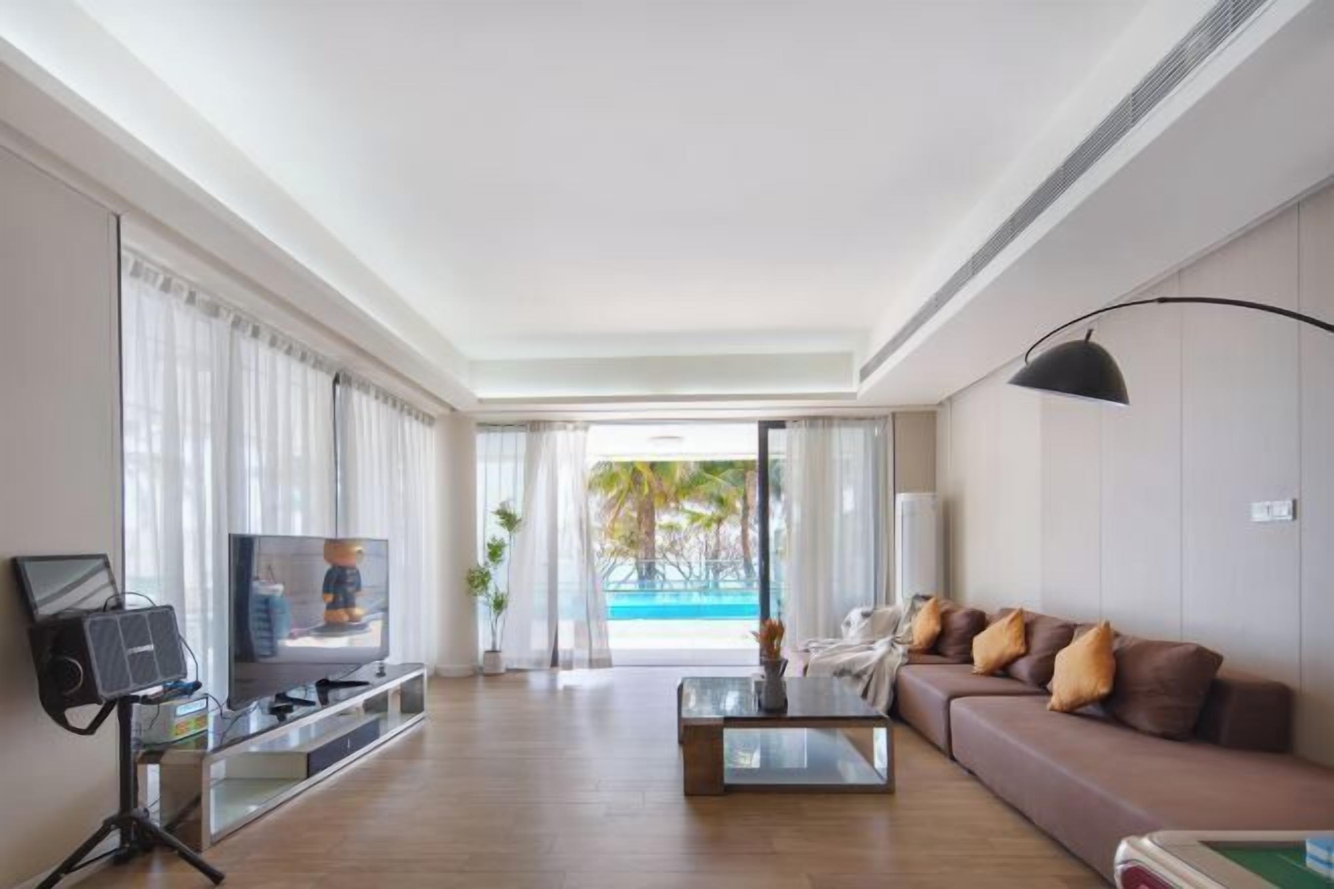 Uma sala de estar moderna com televisão, mesa de centro e sofá.