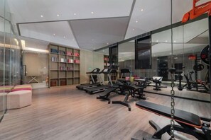 Uma academia moderna com equipamentos de ginástica, um espelho e uma estante de livros.
