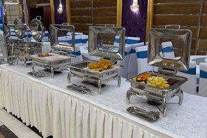Uma mesa de buffet com vários recipientes de comida e utensílios de servir.