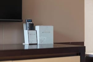 Um controle remoto e uma caixa sobre uma superfície refletora, possivelmente um balcão ou mesa.