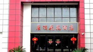 Fachada de hotel com esquema de cores vermelho e branco e sinalização chinesa.