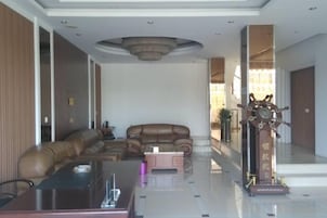 Uma sala de estar ampla com um sofá seccional, uma mesa de centro e um leme decorativo.