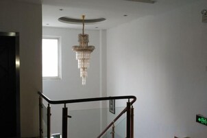 Uma escadaria com guarda-corpo de vidro e um candelabro.