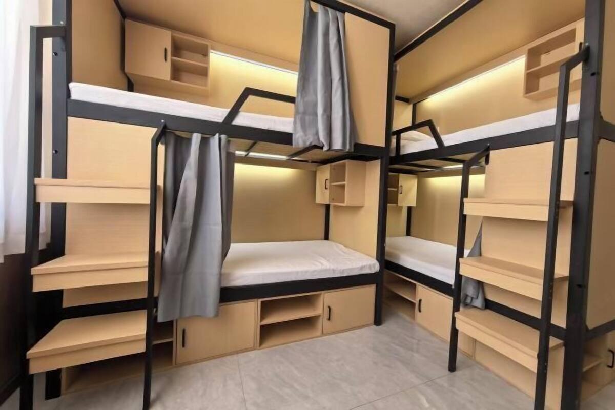 Quarto com beliche, compartimentos de armazenamento embutidos e pequena área de estudo.
