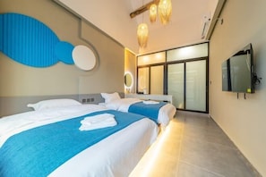 Quarto de hotel com duas camas, um espelho grande, televisão e design moderno.