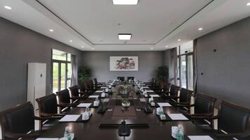 Uma sala de conferência com uma mesa comprida, cadeiras e um projetor.