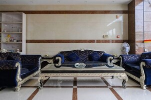 Sala de estar com sofá, mesa de centro e ventilador.