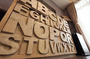 Parede de madeira com o alfabeto em letras maiúsculas.