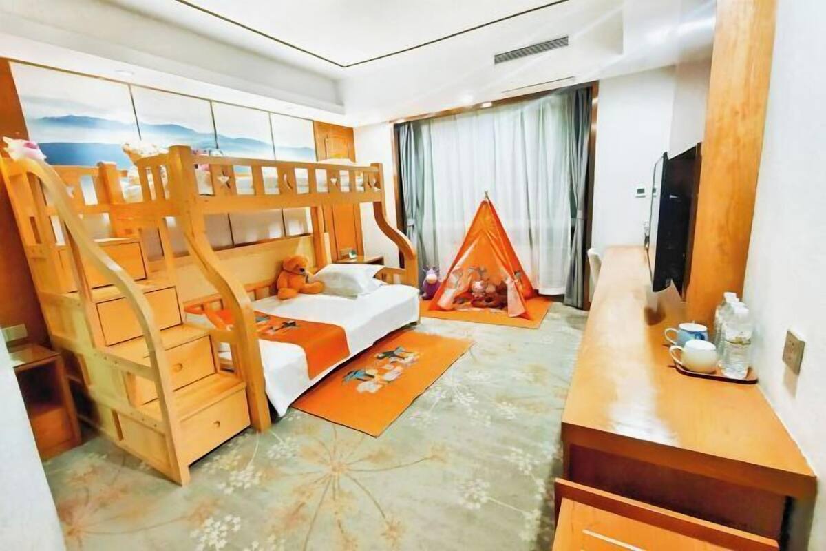 Quarto ideal para crianças, com cama beliche, tenda de brincar e escrivaninha com cadeira.