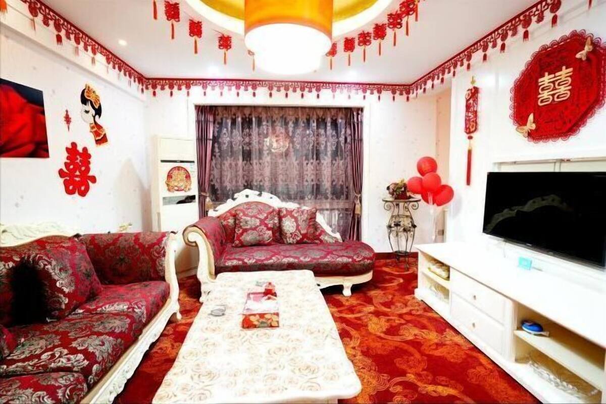 Uma sala de estar com sofá, mesa de centro, TV e decoração na parede.