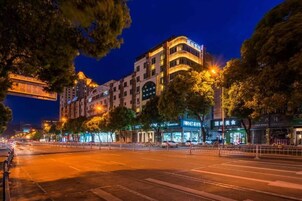 Hotel de vários andares com design moderno, destacando uma entrada imponente e uma ampla área de varanda.