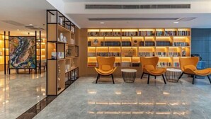 Uma biblioteca moderna com estantes, assentos confortáveis e piso de mármore.