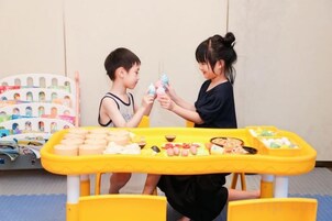Duas pessoas sentadas à mesa amarela, com diversos pratos.
