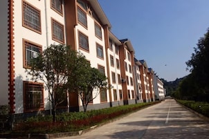 Um edifício de vários andares com uma longa entrada e uma fileira de janelas no andar térreo.
