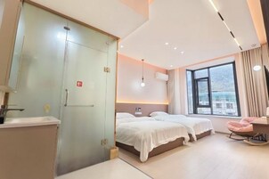 Quarto de hotel moderno com guarda-roupa de vidro, uma cama grande, uma escrivaninha e vista para a cidade.