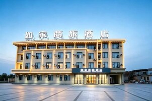 Um hotel com fachada plana, várias janelas e uma placa com caracteres chineses.