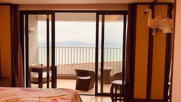Quarto de hotel com cama, varanda e decoração com cisne.