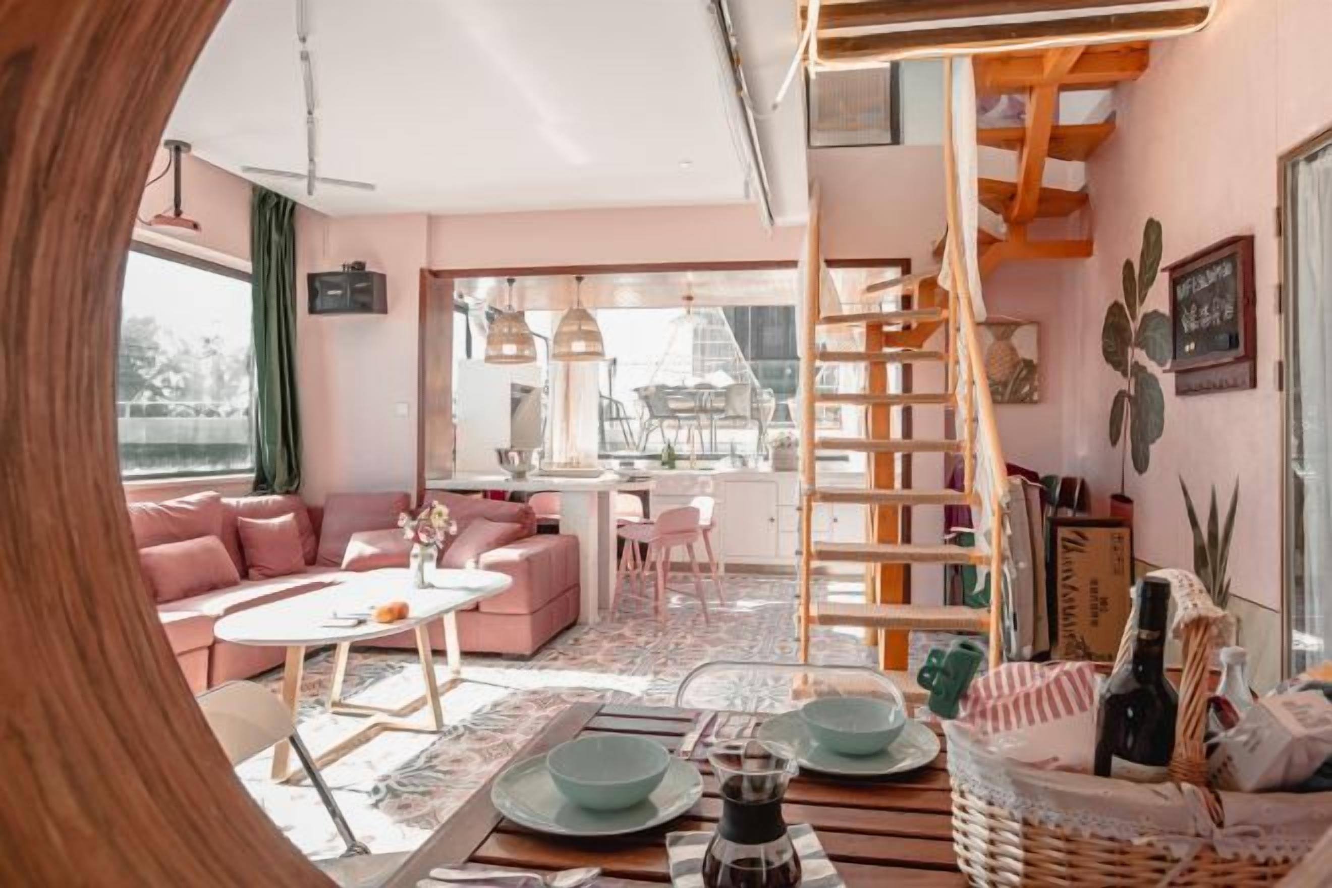 Um interior acolhedor com sofá, mesa de jantar e escada.