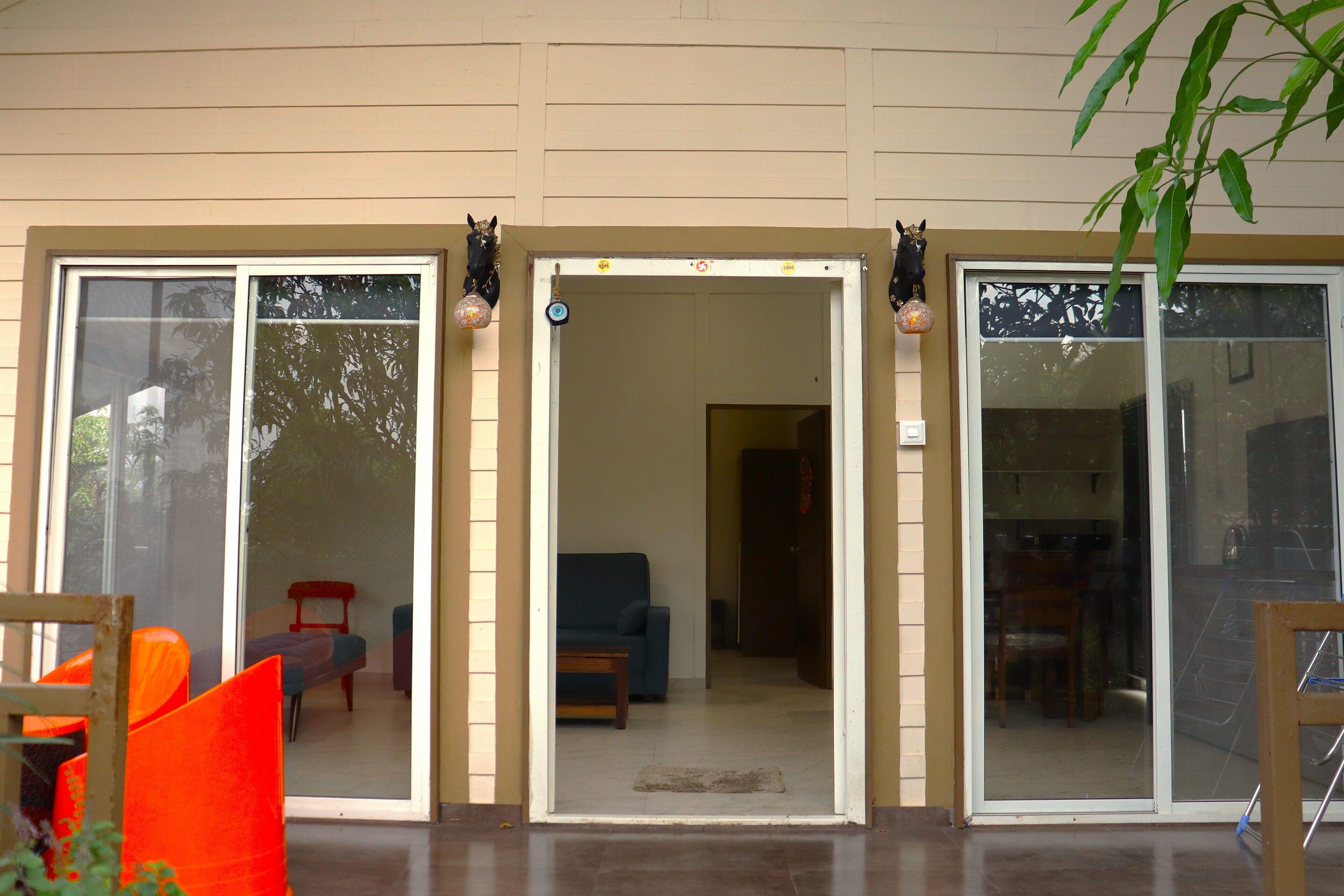 Uma entrada de casa com porta de vidro deslizante que dá para uma sala de estar com sofá e mesa de centro.