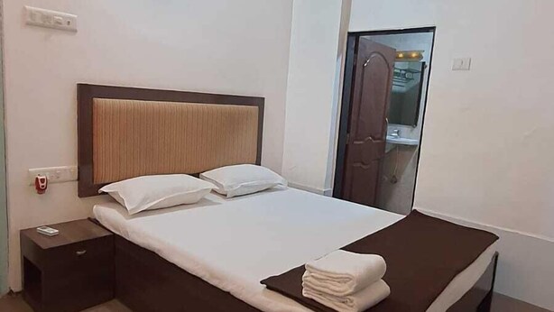 Quarto de hotel moderno com uma cama grande, uma mesa de cabeceira e um guarda-roupa.