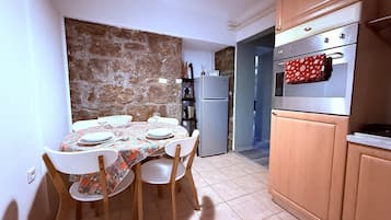 Apartamento, pátio, vista para o jardim | Cozinha privada | Um frigorífico/congelador grande, um forno, uma placa de cozinha