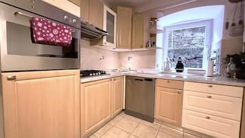 Apartamento, pátio, vista para o jardim | Cozinha privada | Um frigorífico/congelador grande, um forno, uma placa de cozinha