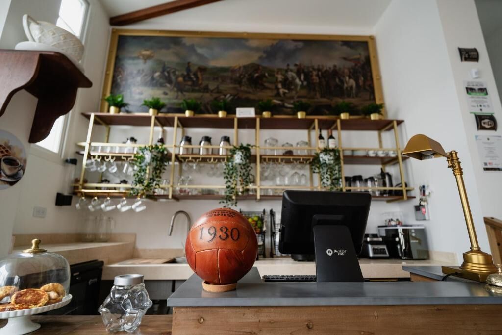 Uma cozinha com bancada de madeira, um laptop, uma bola de basquete e uma cafeteira.