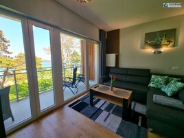 Apartamento conforto, sacada, vista para o mar | Área de estar | TV LCD 50 polegadas com canais a cabo