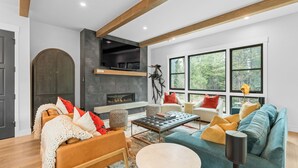 Uma sala de estar moderna com lareira, janelas amplas e um espaço de estar aconchegante.