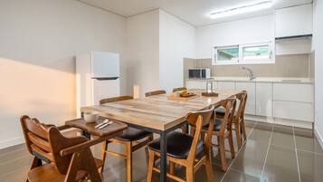 Uma cozinha moderna com armários brancos, micro-ondas e pia.