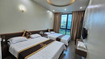 Quarto de hotel com duas camas, varanda e vista para o exterior.