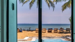 Vista da piscina, praia e palmeiras.