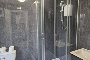 Chuveiro, toalhas de banho, papel higiênico