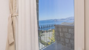 Uma varanda com vista para o mar e montanhas.