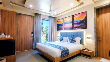 Quarto de hotel moderno com uma cama grande, guarda-roupa de madeira e televisão.