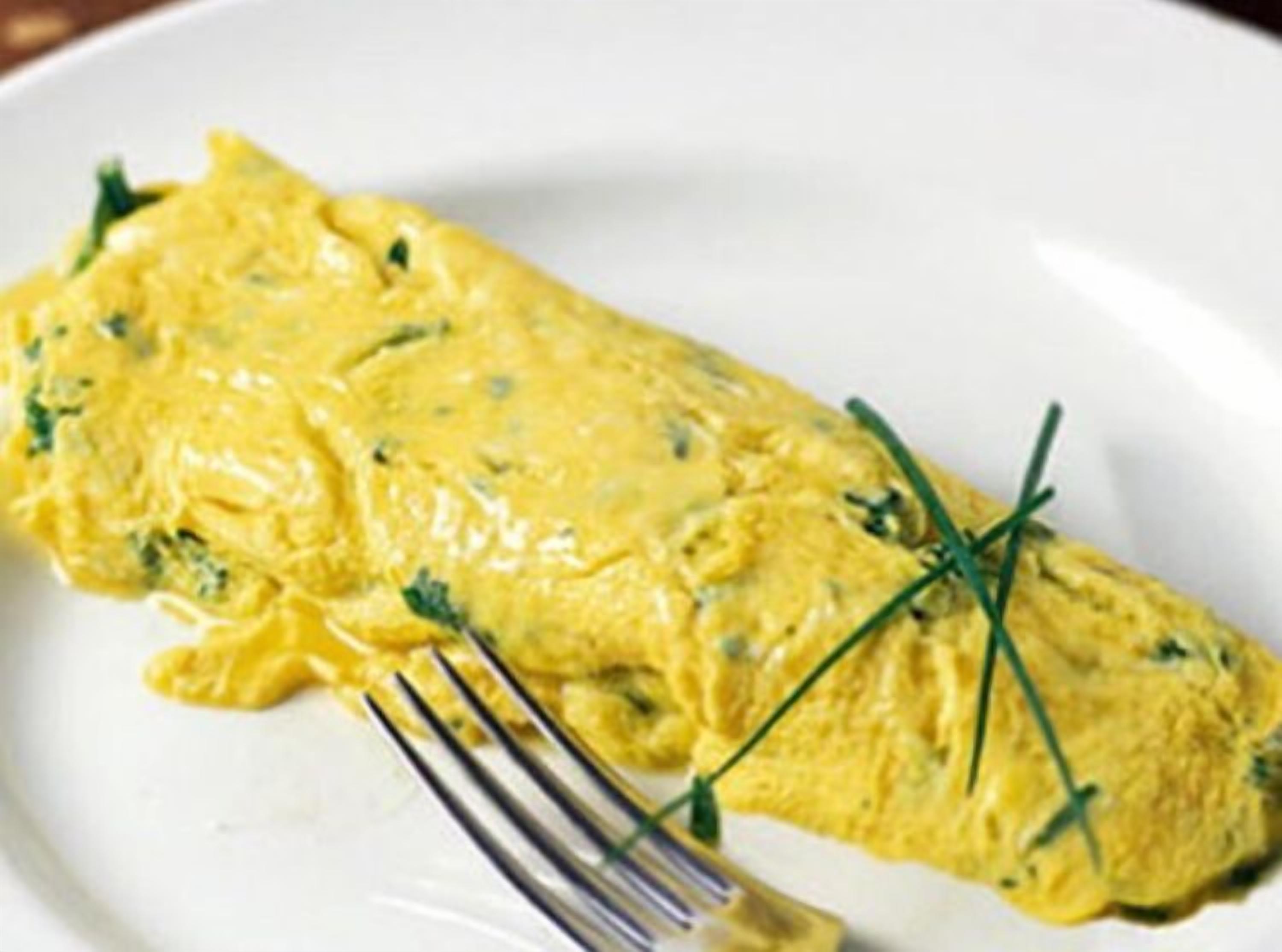 Um prato com uma omelete e um garfo.
