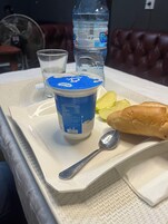 Uma mesa de jantar com um prato de comida, uma garrafa de água, um copo e uma colher.