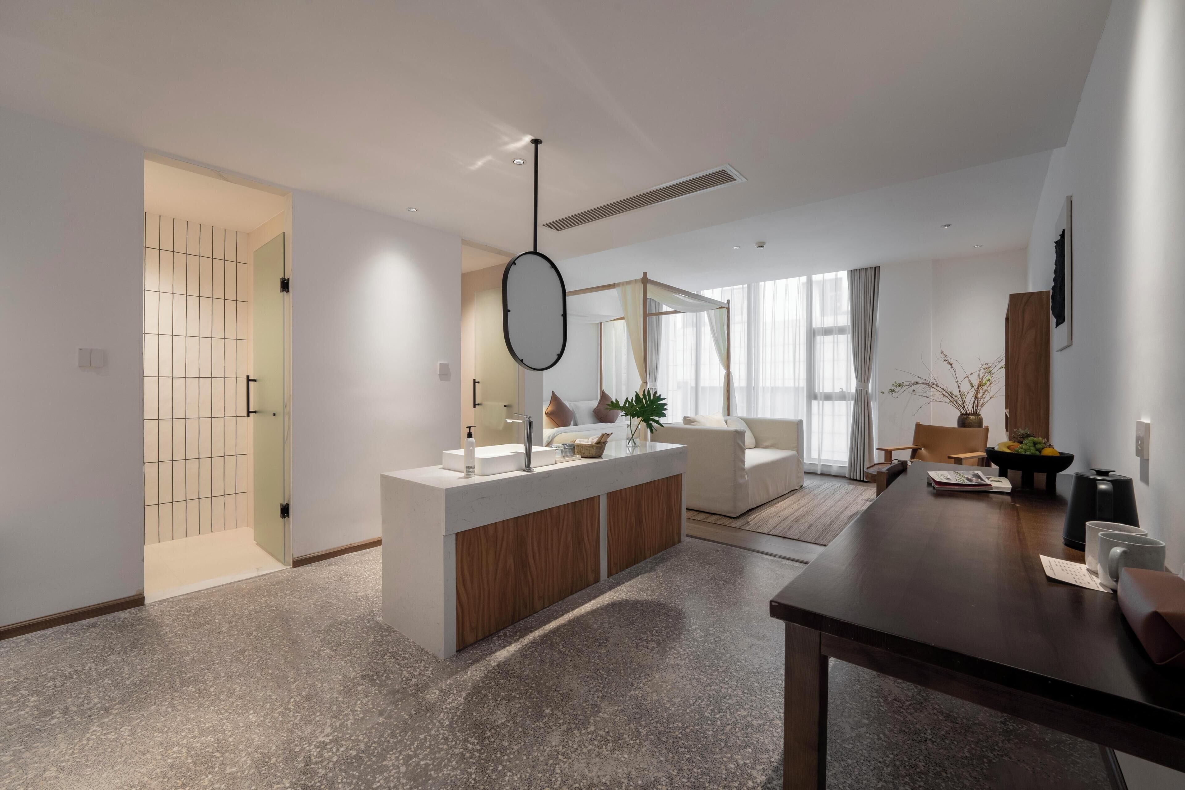 Uma sala de estar moderna com uma ilha central, um sofá e uma mesa de jantar.