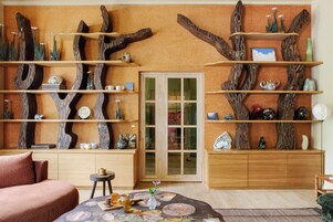 Quarto com um armário de madeira, um sofá e uma mesa de centro com um jogo americano floral.