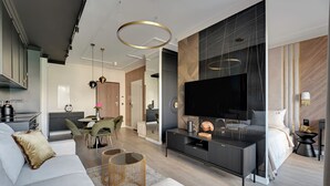Uma sala de estar moderna com sofá, espaço para refeições e TV.