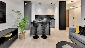 Um apartamento moderno com cozinha, área de refeições e sala de estar.